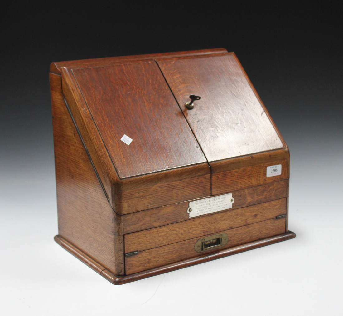 A late Victorian oak stationery box, the double-hinged sloping lid ...